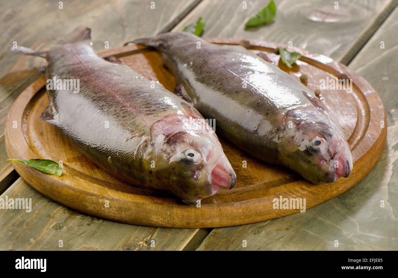 Rainbow trouts on a wooden table. Selective focus Stock Photo - Alamy