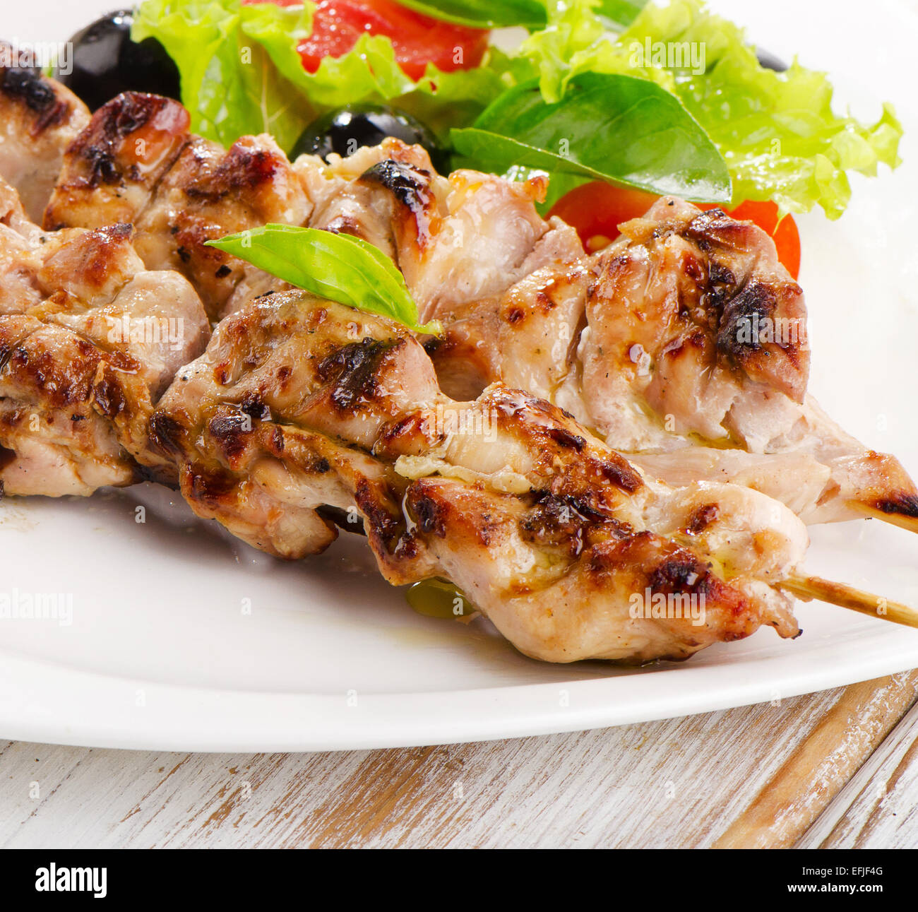 Grilled chicken kebab on a white plate. Selective focus Stock Photo - Alamy