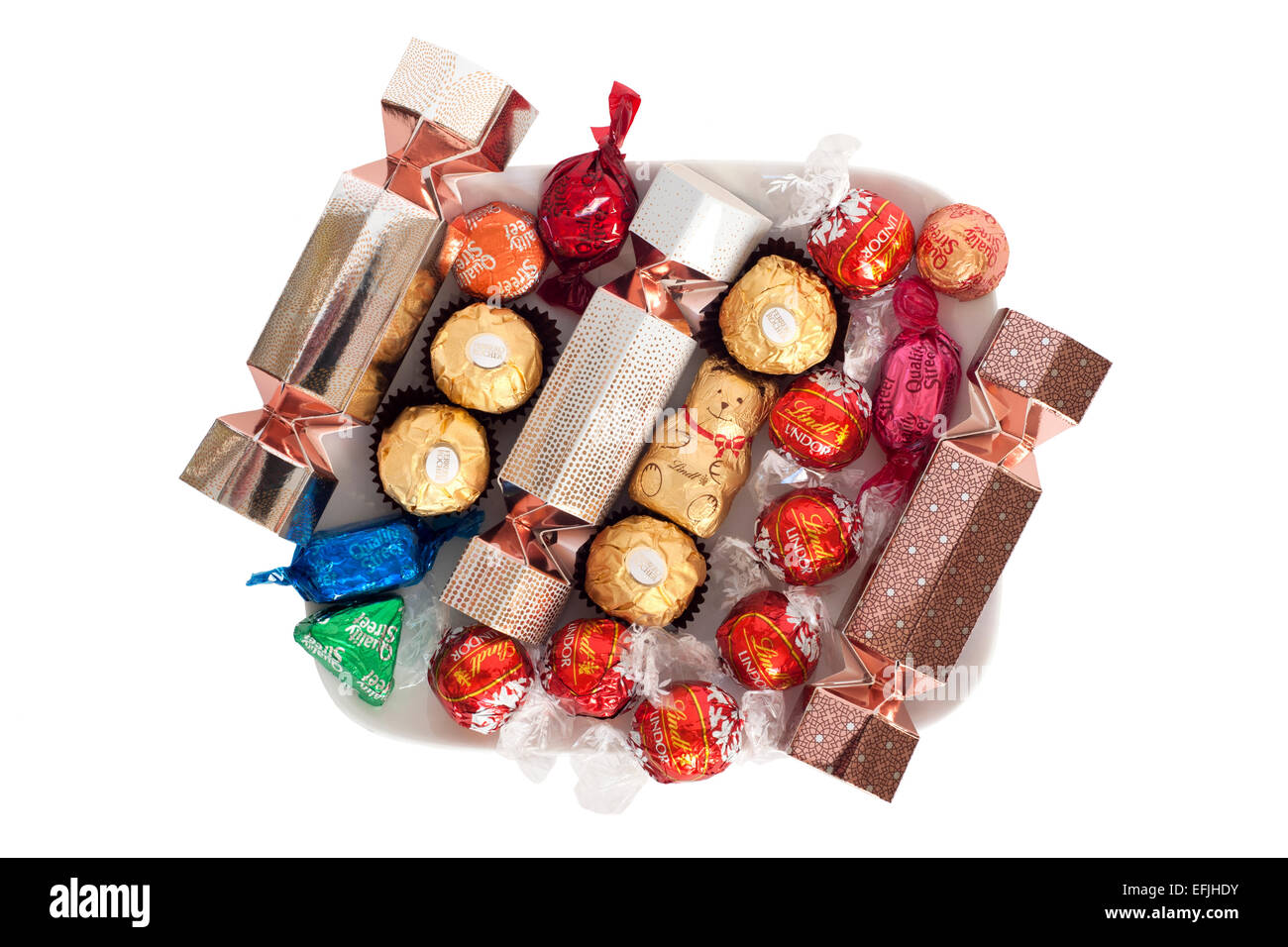 assorted chocolates on a plate isolated against a white background ...