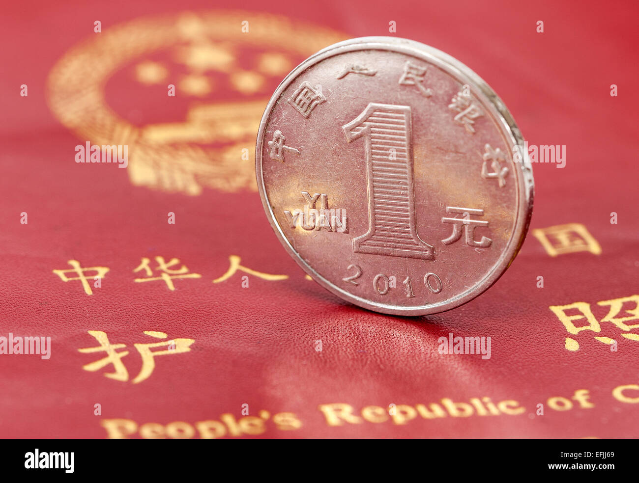 Chinese one yuan coin against the background of the Chinese passport ...