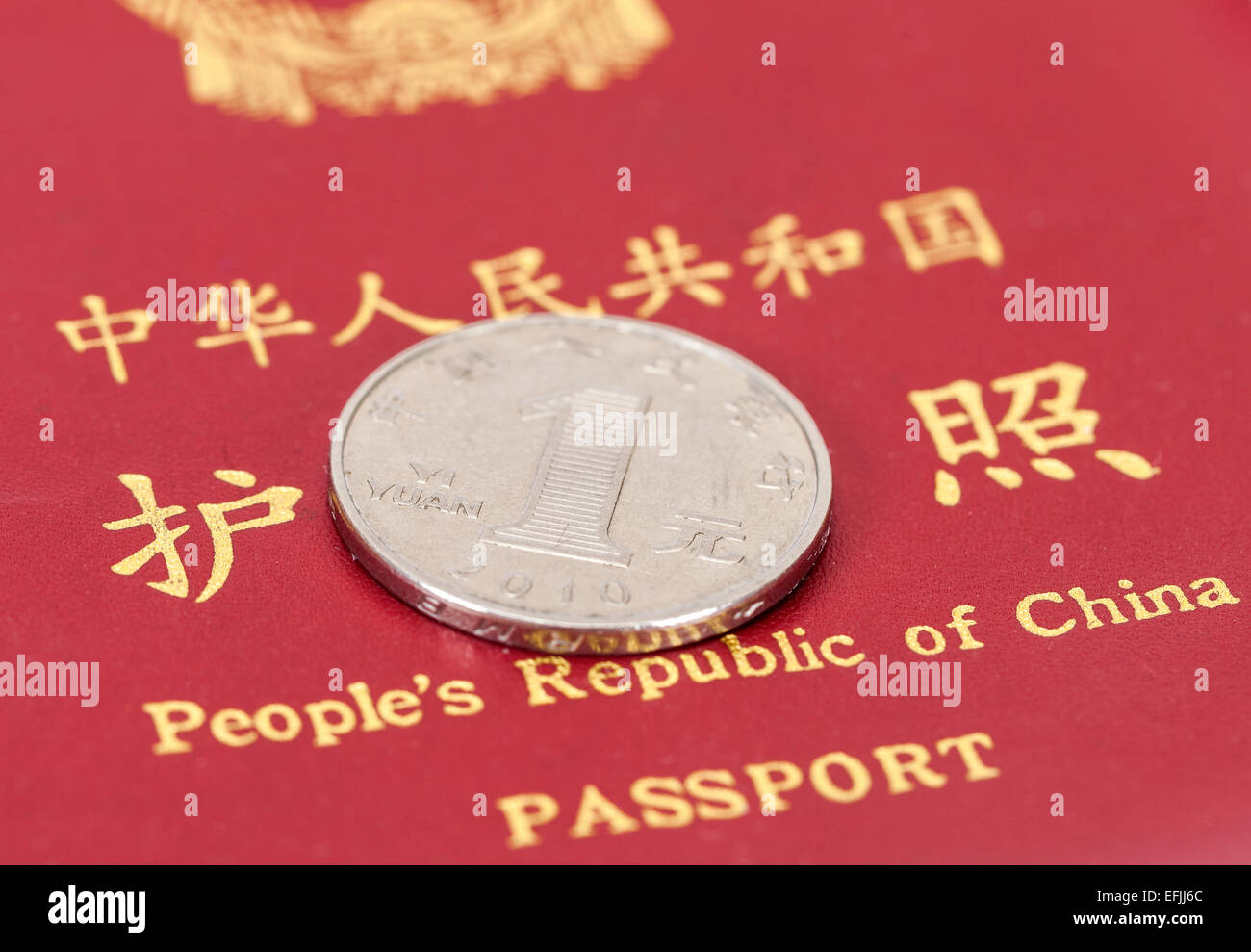 Chinese one yuan coin against the background of the Chinese passport ...