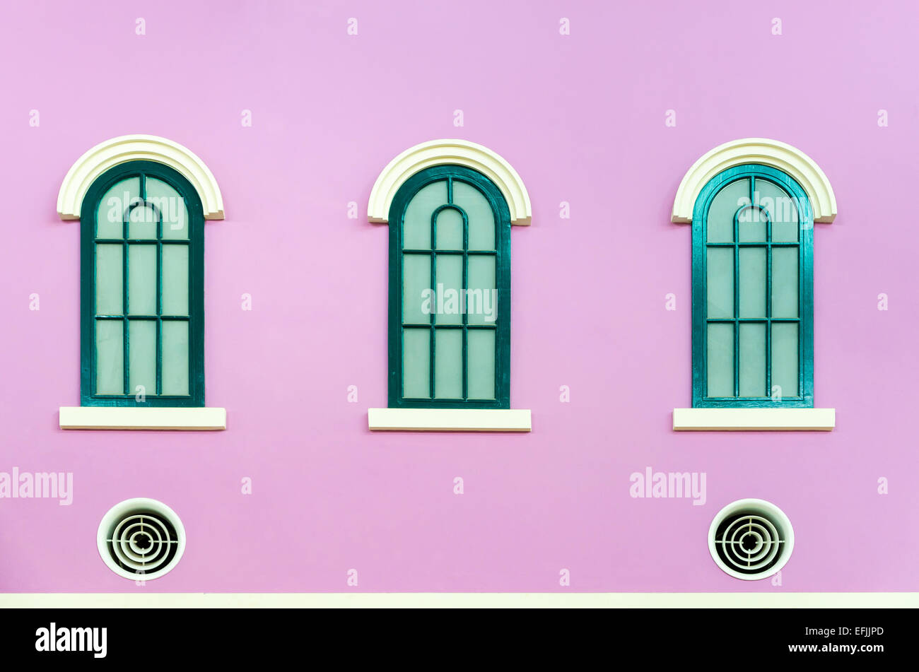 Three green arched windows on pink wall of the house in Italy retro ...