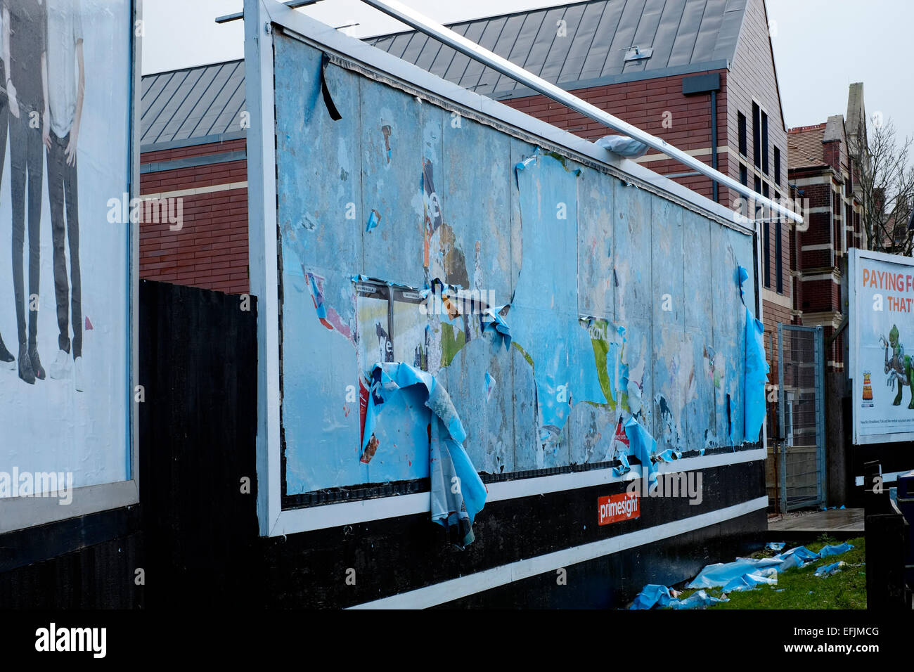 torn and ripped billboard poster hangs down in strips awaiting ...