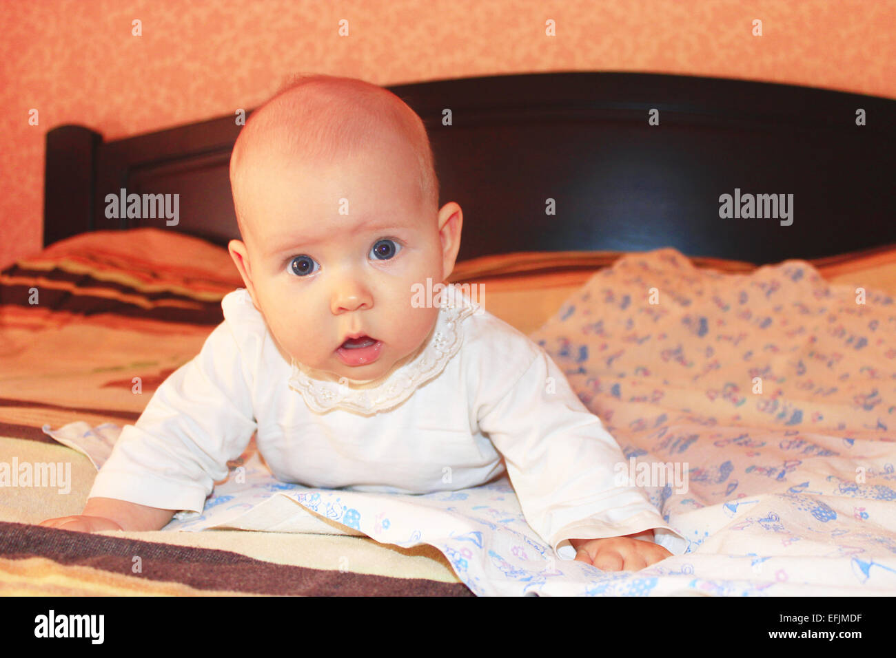 little lovely baby lying on the bed in marvelous pose Stock Photo - Alamy