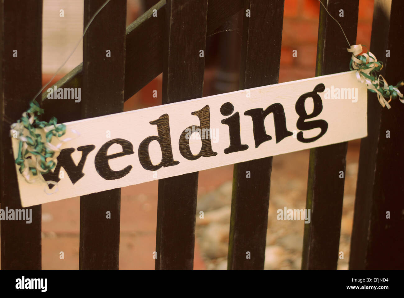 A sign for a wedding hanging on a black wooden gate Stock Photo - Alamy