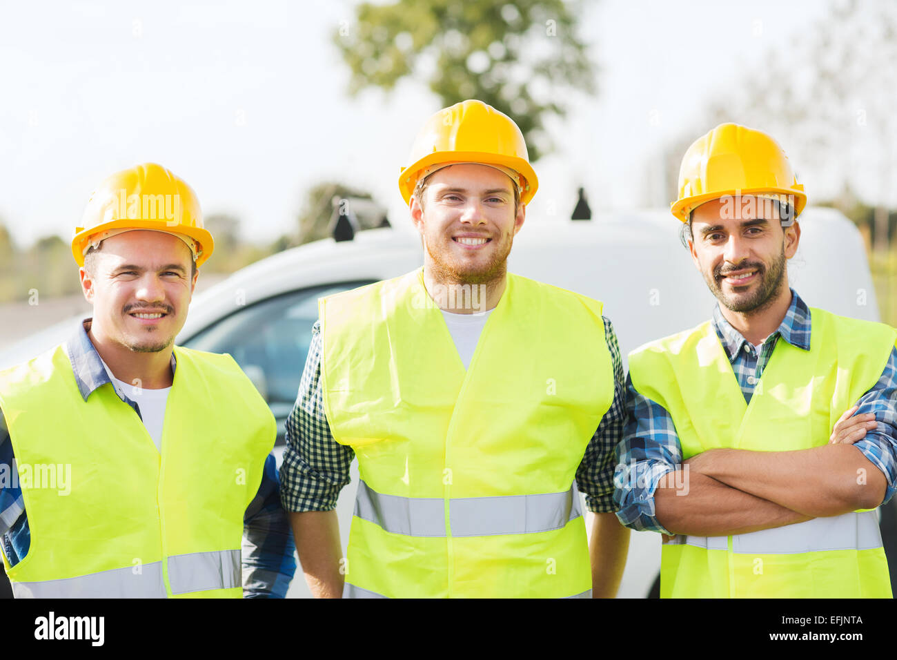 group of smiling builders in hardhats outdoors Stock Photo - Alamy