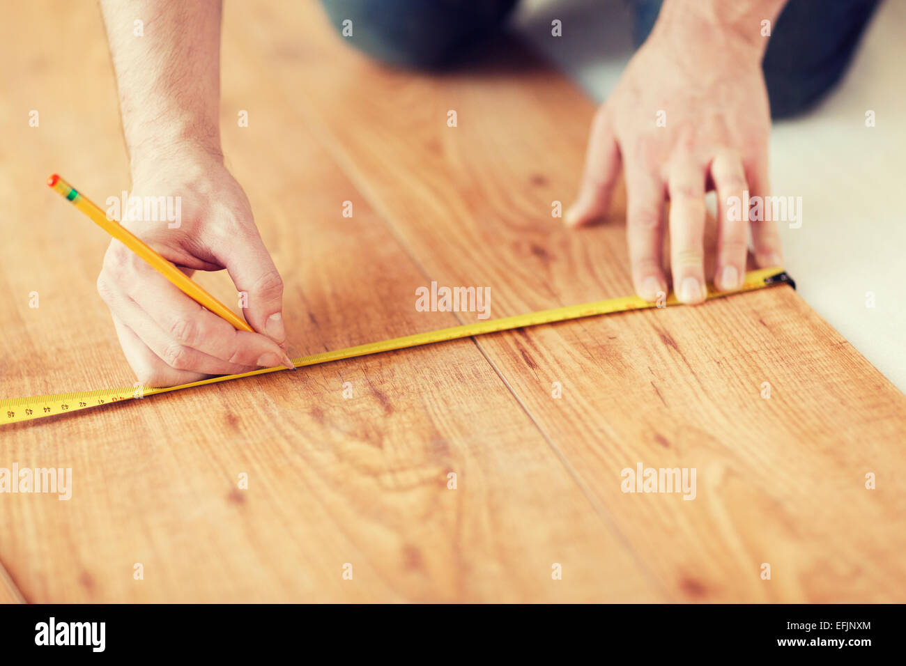 close up of male hands measuring wood flooring Stock Photo - Alamy