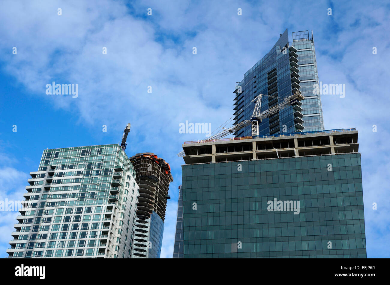 Modern glass and steel skyscrapers under construction in downtown ...
