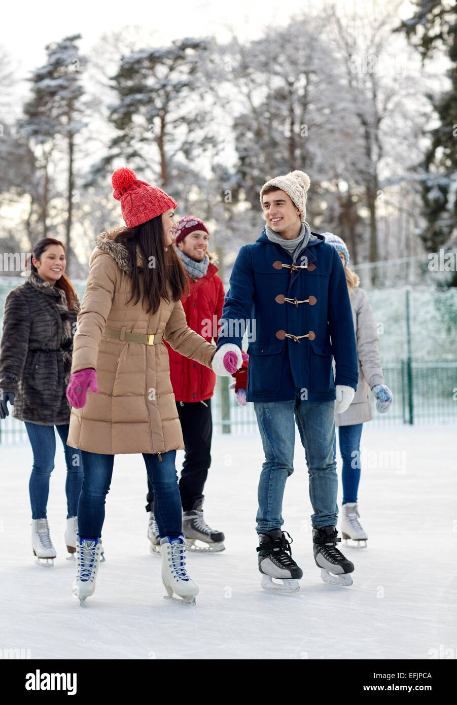 happy friends ice skating on rink outdoors Stock Photo - Alamy