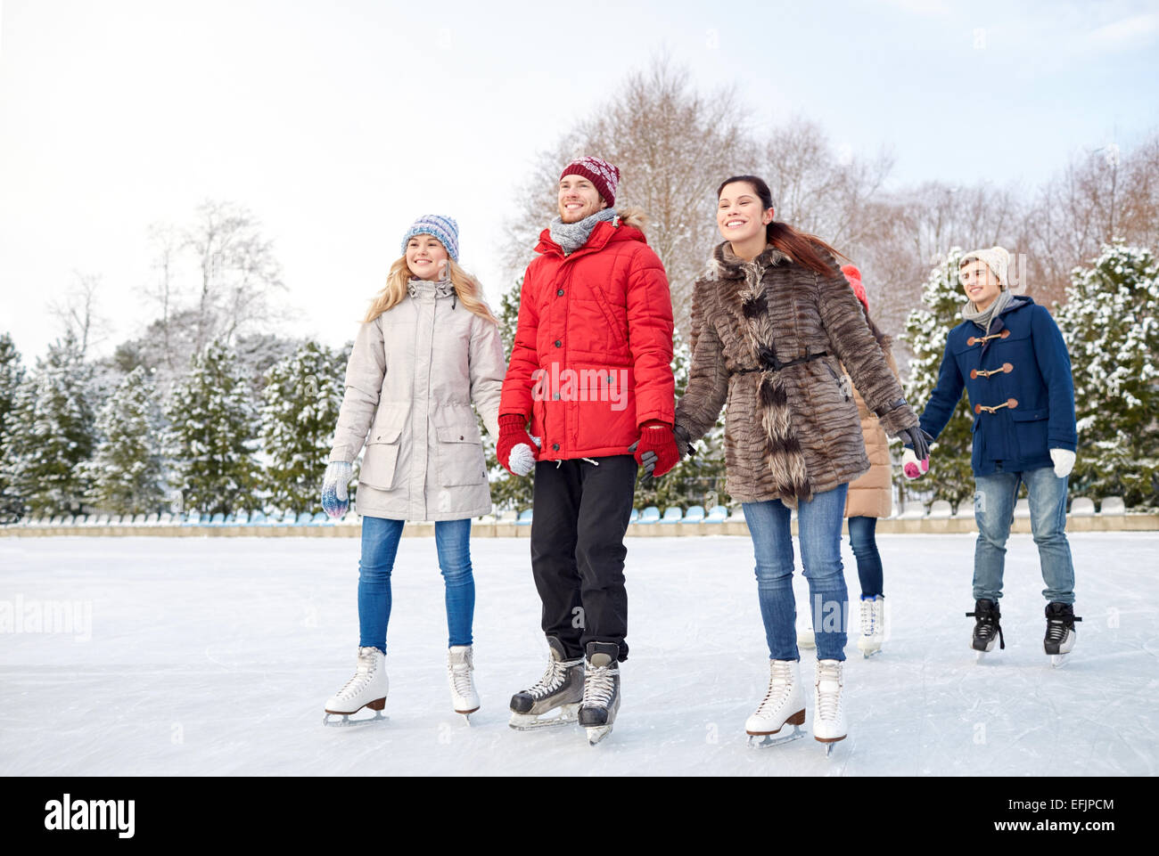 happy friends ice skating on rink outdoors Stock Photo - Alamy