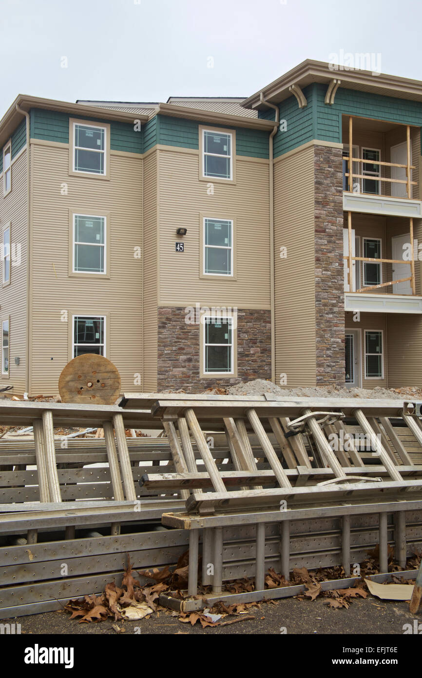 Stack of ladders at construction site in front new apartment building ...