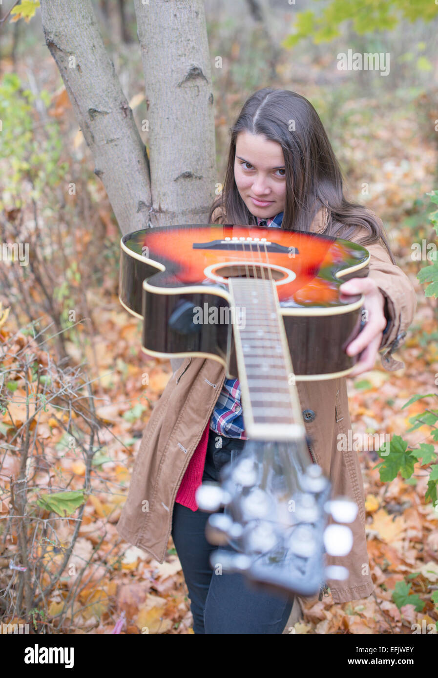 Young woman fighting with her guitar Stock Photo - Alamy