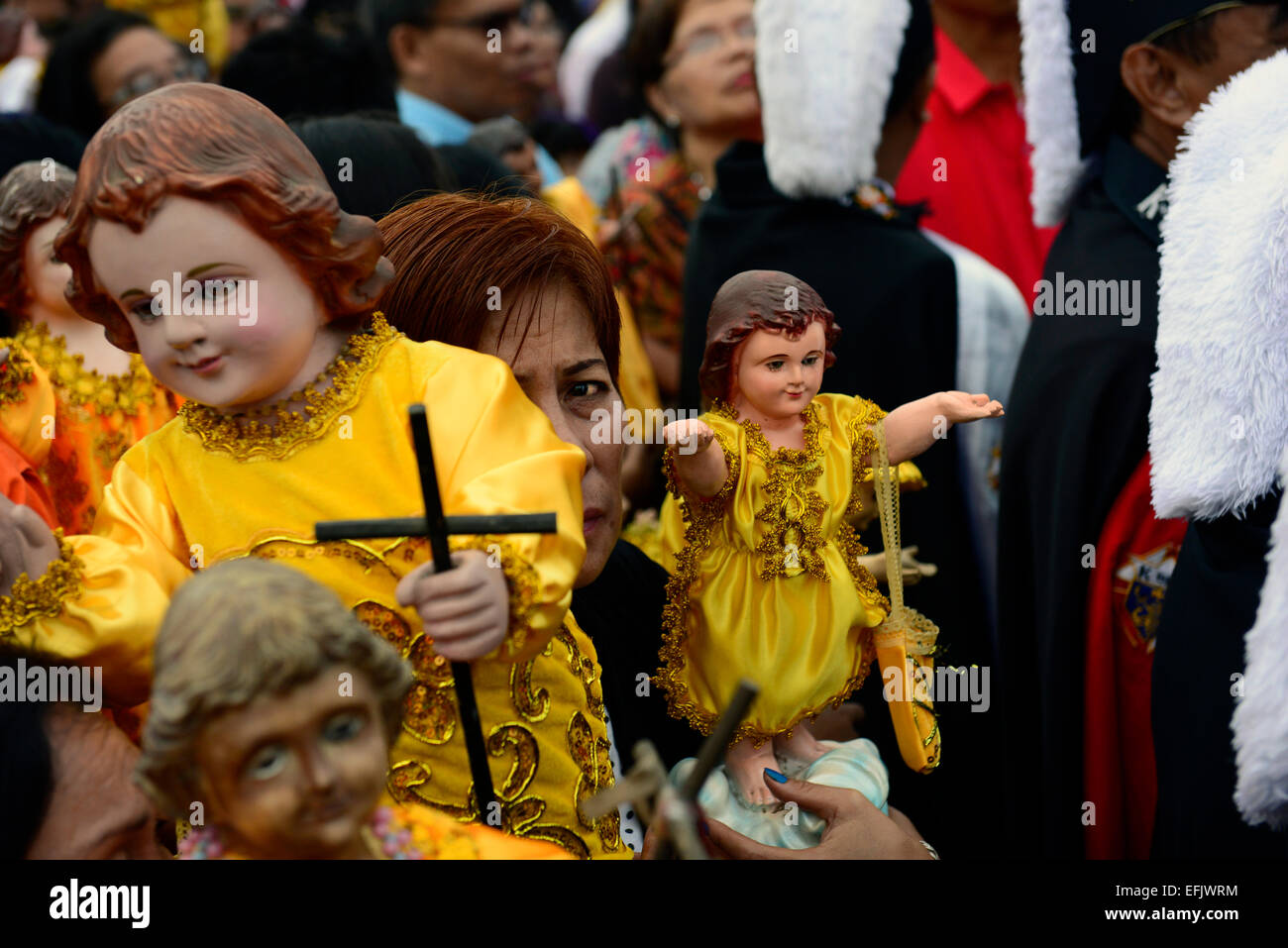 A Filipino crowed, holding small statues of Santo Niño ( infant Jesus ...