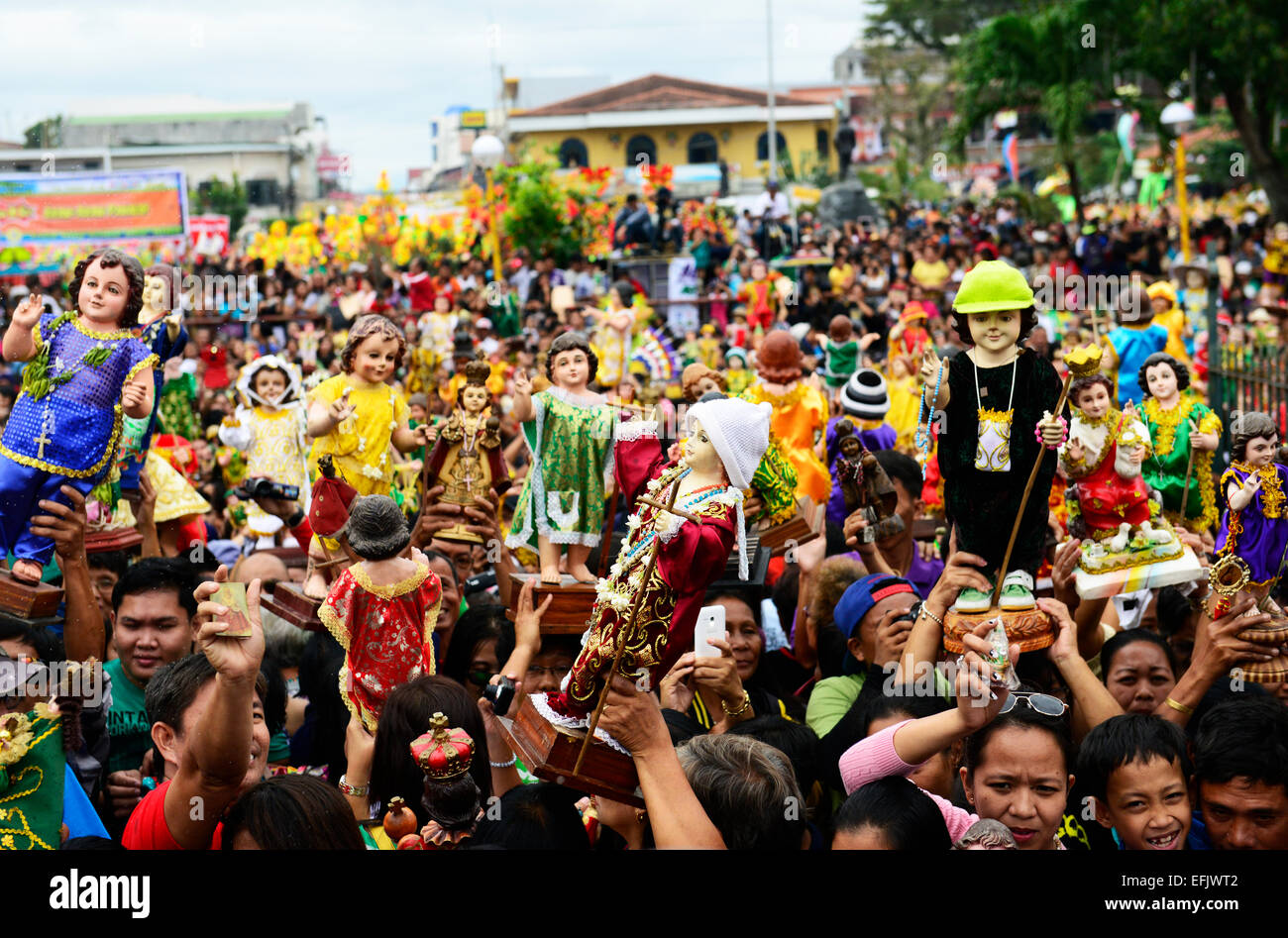 A Filipino crowed, holding small statues of Santo Niño ( infant Jesus ...