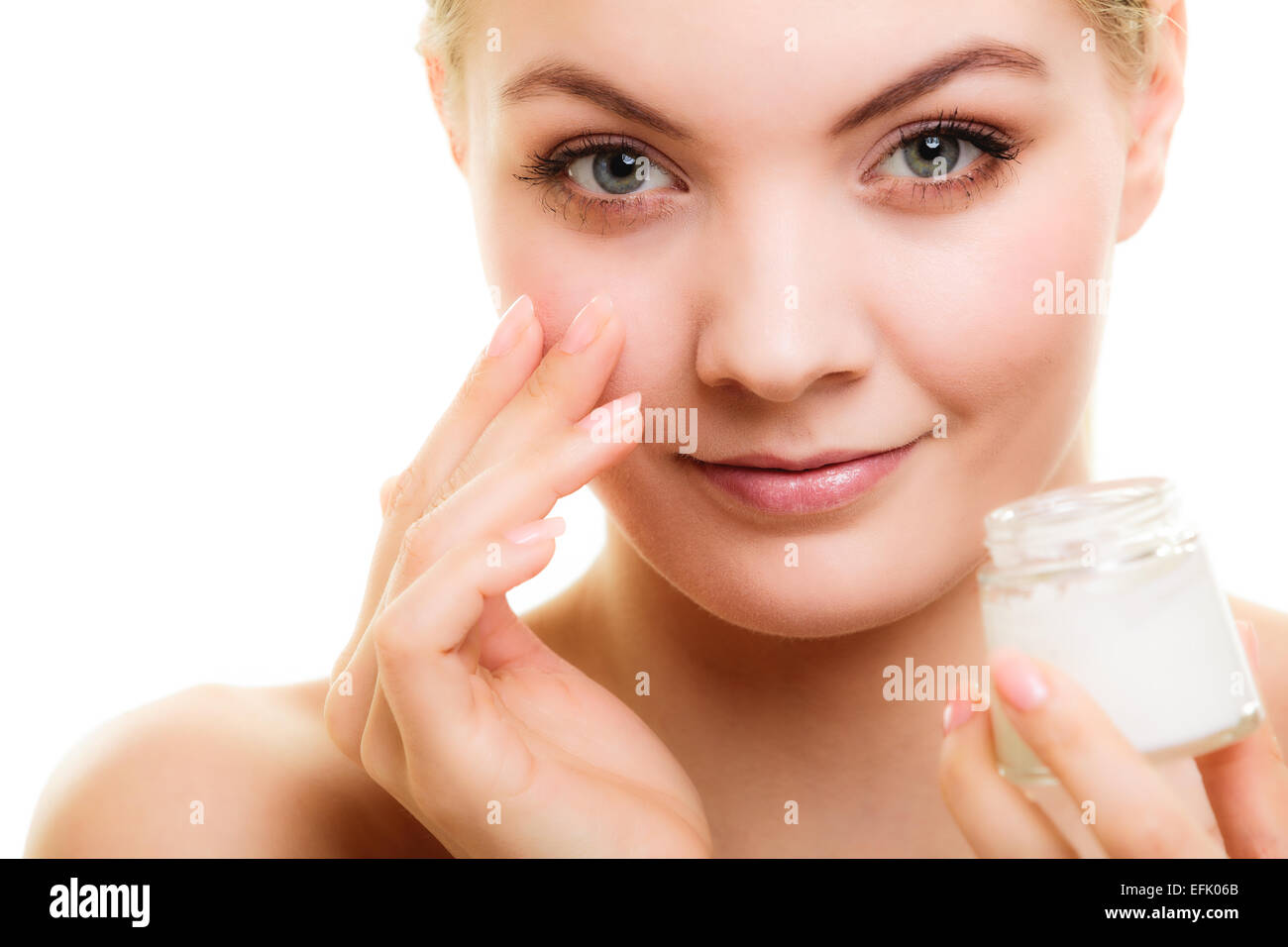 Skincare. Young woman holding lotion jar. Blond girl taking care of her ...