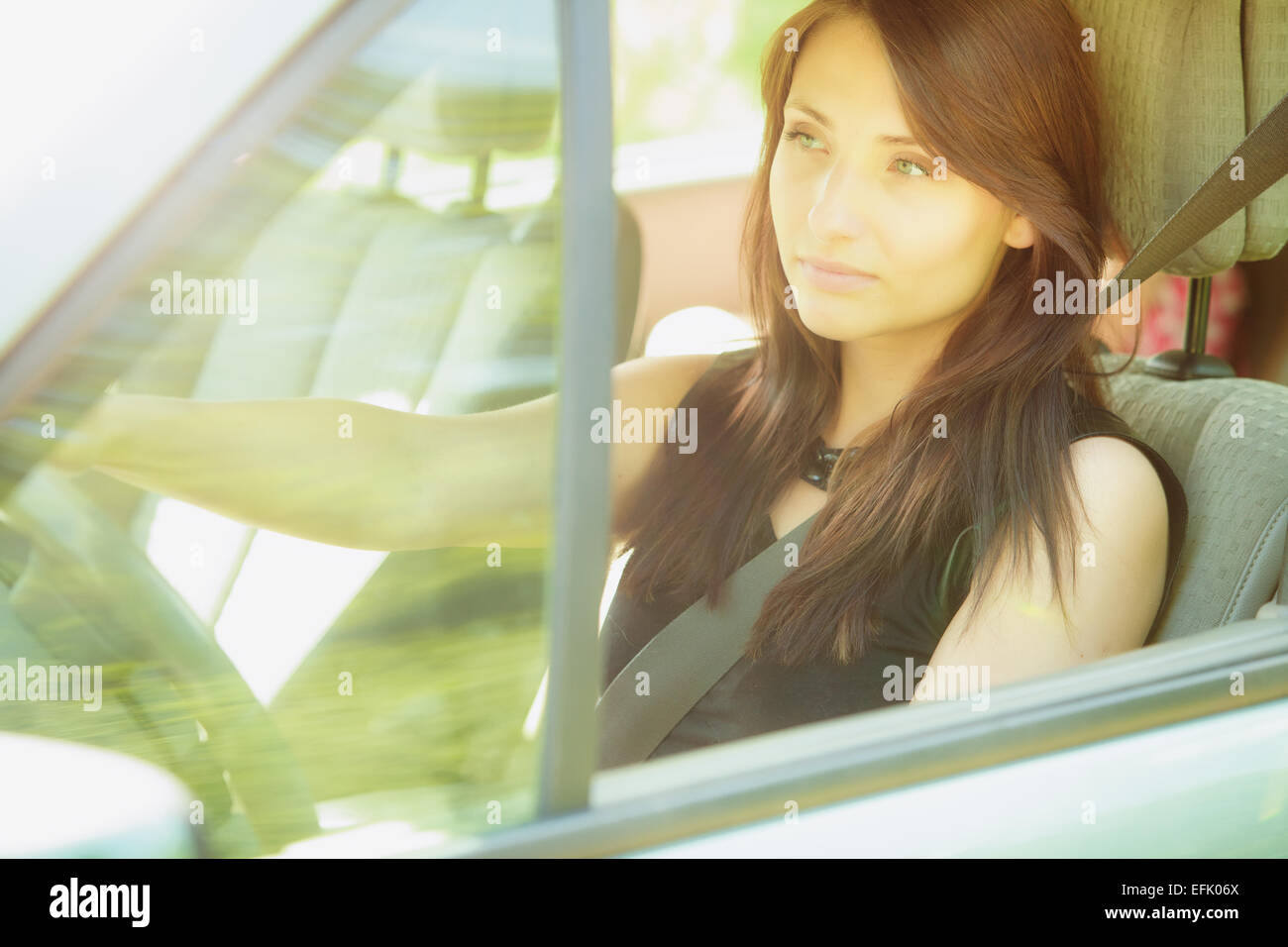 Road transportation. Beautiful young woman driver driving a car ...