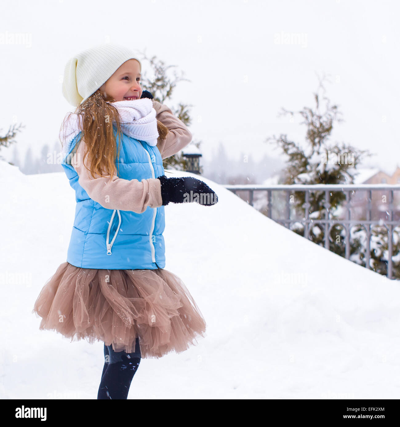 Adorable little girl playing snowballs in winter outdoors Stock Photo ...