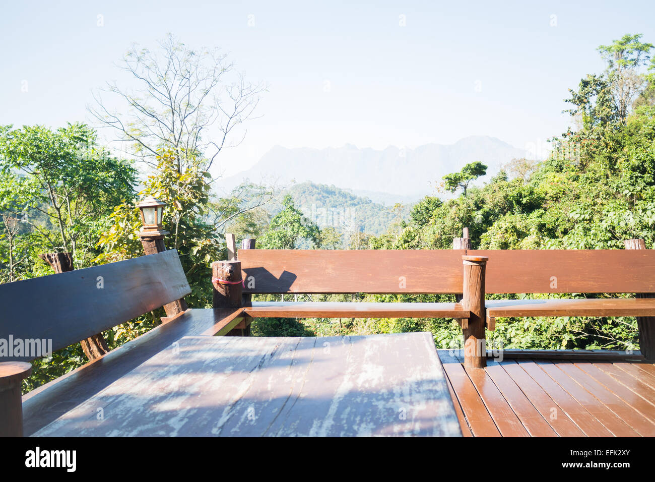 Outdoor wooden seating area with green forest scenery, stock photo ...