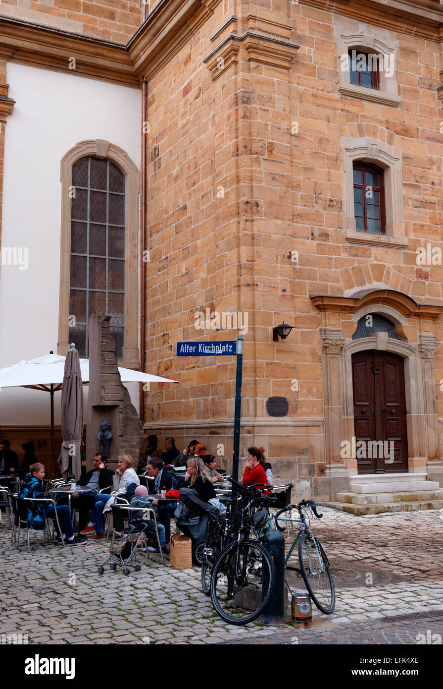 Dining in the street by an old Church in Arlen, Germany, with bicycles ...