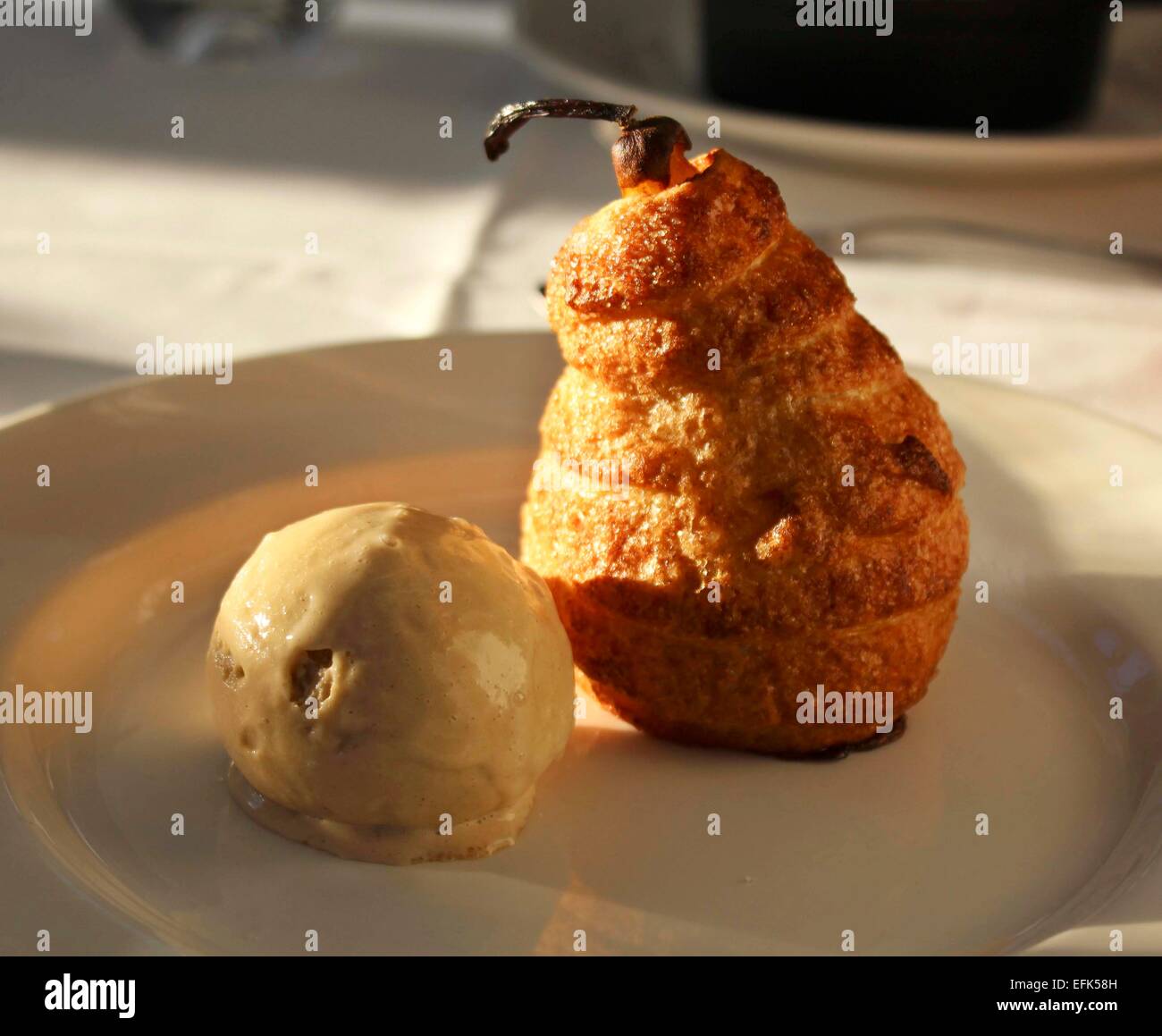 Boozy baked conference pear with cinnamon ice cream Stock Photo - Alamy