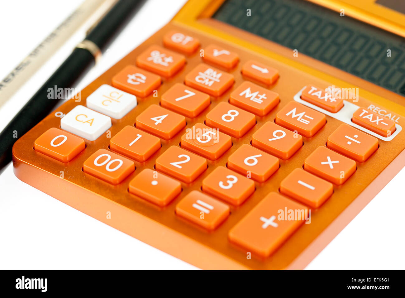 An orange calculator with a pen and pencil on the left hand side Stock ...
