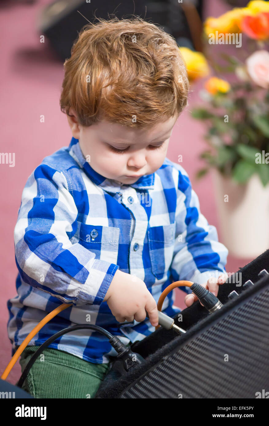 Little boy putting a cable into a speaker Stock Photo - Alamy