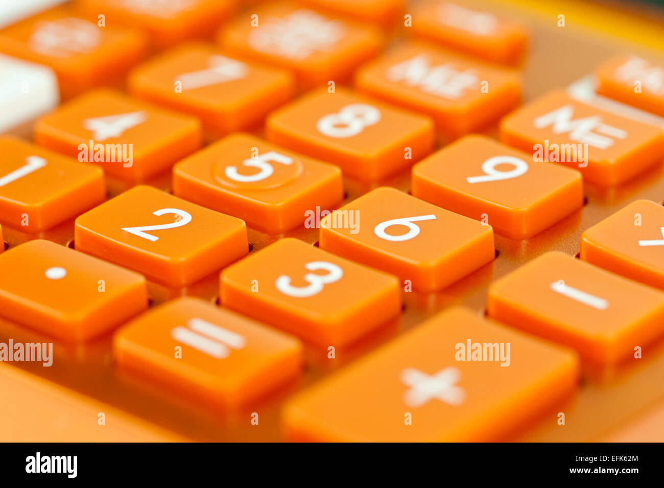A close image of the number pad on an orange calculator. A narrow depth ...