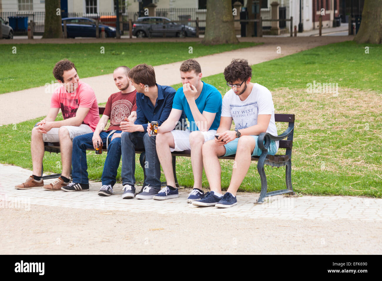 Five young men sat on bench at park in Bristol in May Stock Photo - Alamy