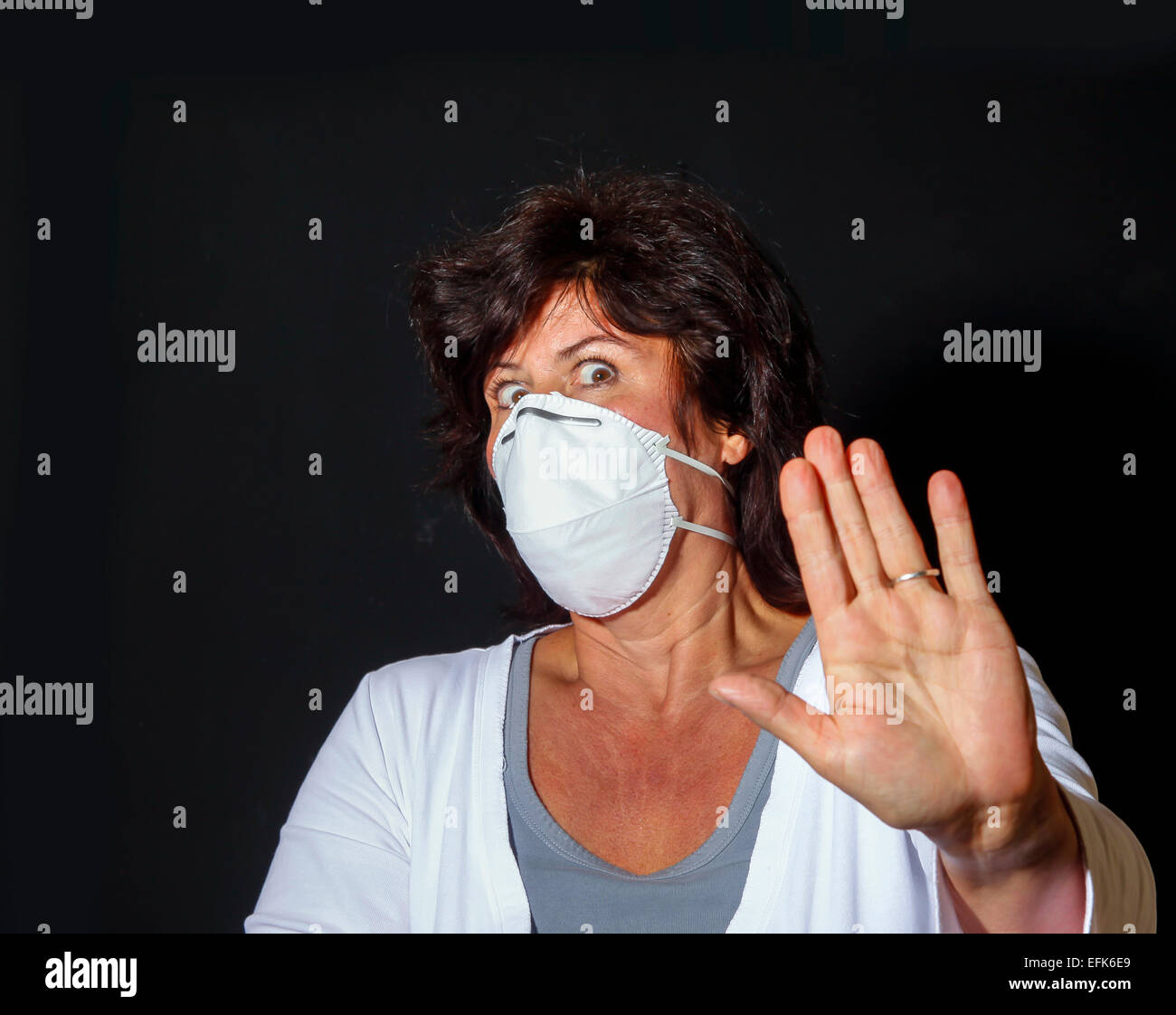 Woman with mouth mask holding up hand to keep flu away Stock Photo - Alamy