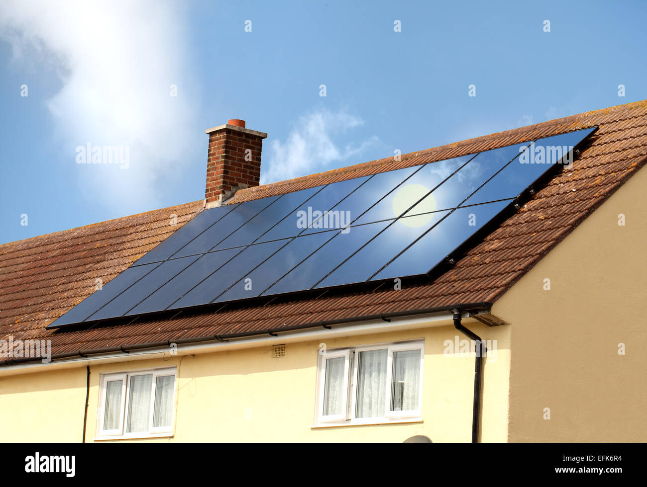 The Sun reflecting from sixteen solar panels on a house roof, giving a ...