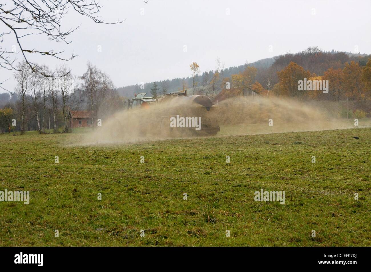 Spraying of tanker liquid manure on a meadow in late autumn. Tanker ...