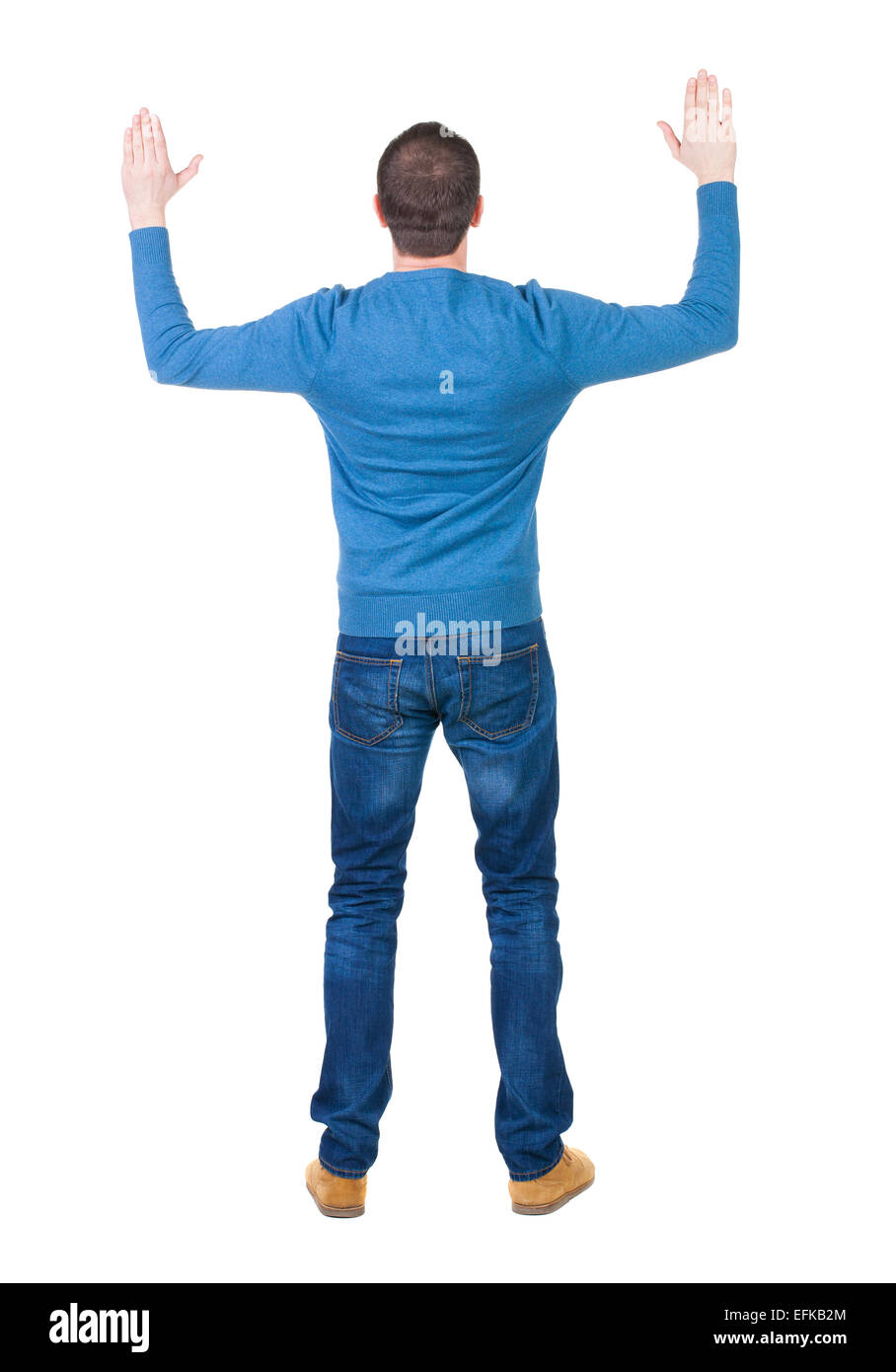 Back view of handsome man in blue pullover looking up. Standing young ...