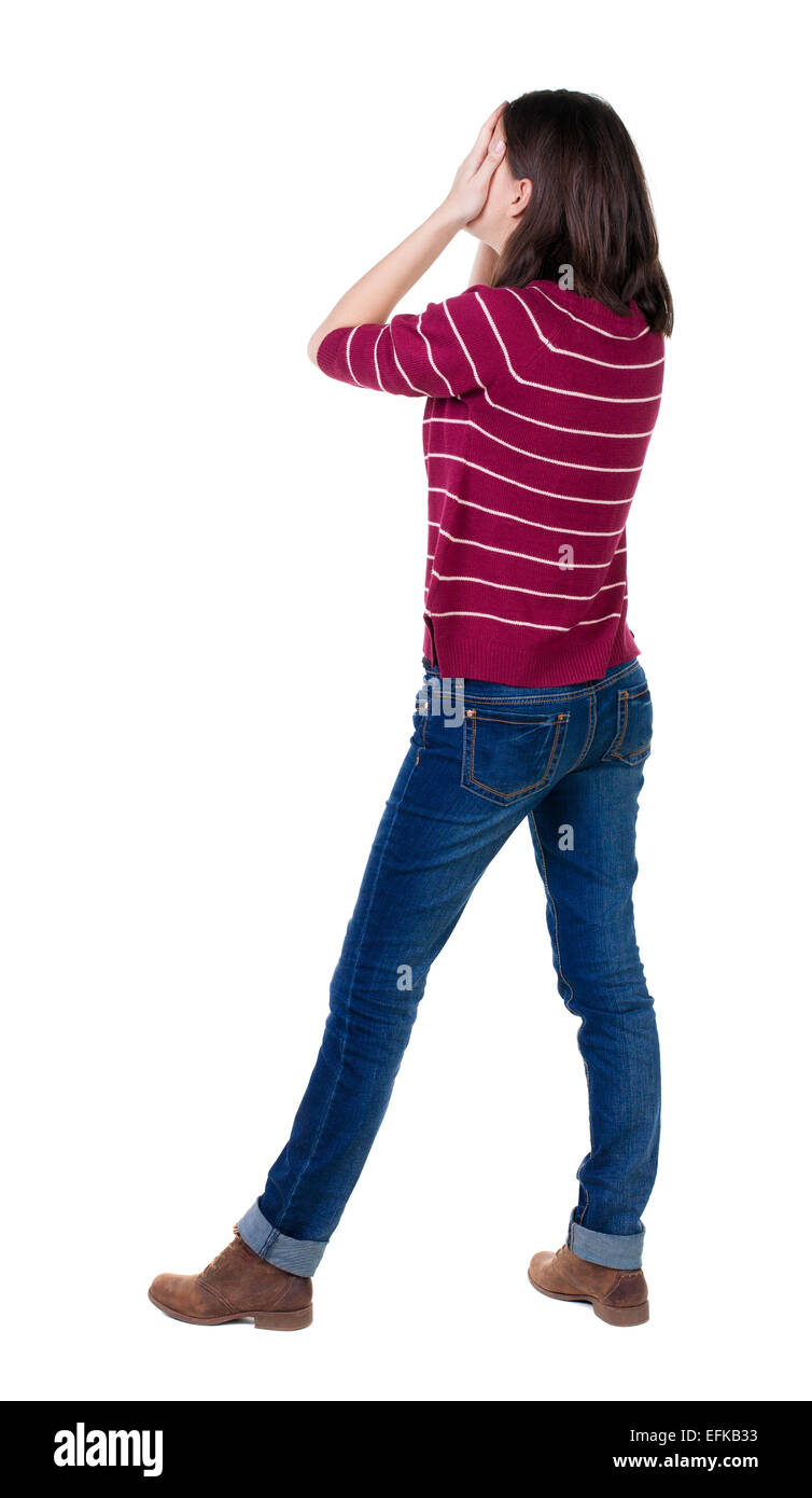 Back view of shocked woman in blue jeans. girl hid his eyes behind his ...