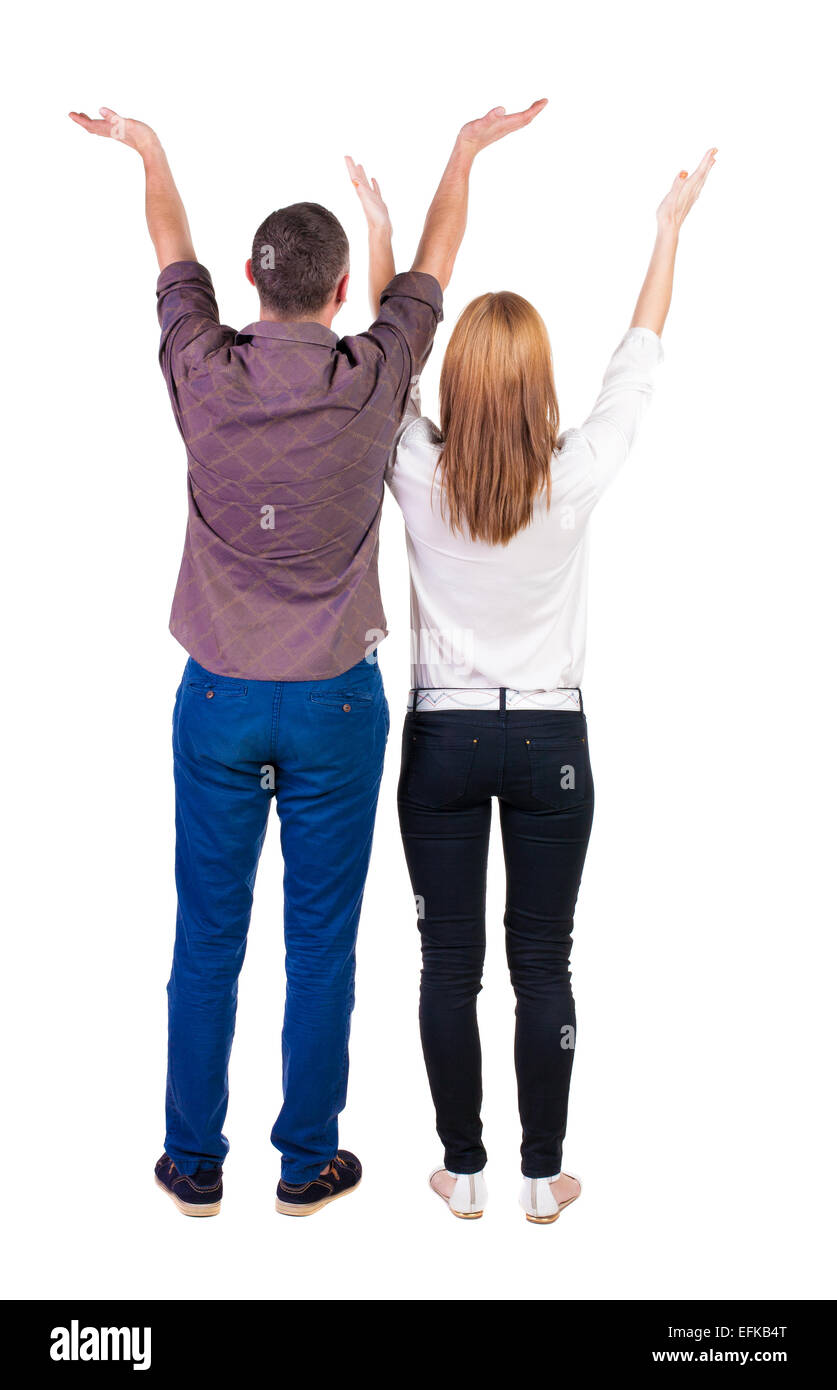 Back view couple looking at wall and Holds hand up. Rear view people ...