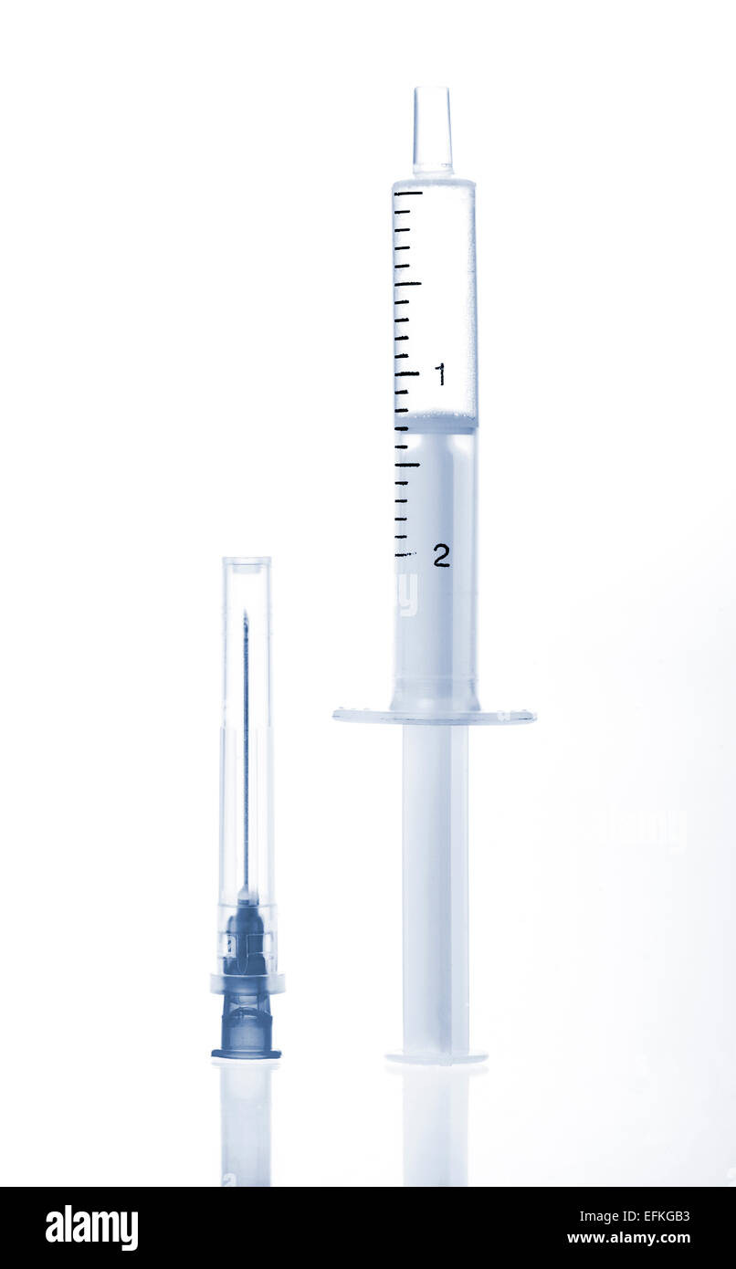 Plastic syringe and needle with cap on a white background. Tinted image ...