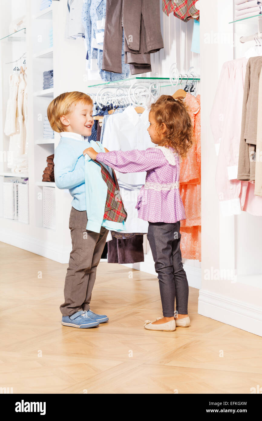 Laughing cute boy and girl choose clothes together Stock Photo - Alamy