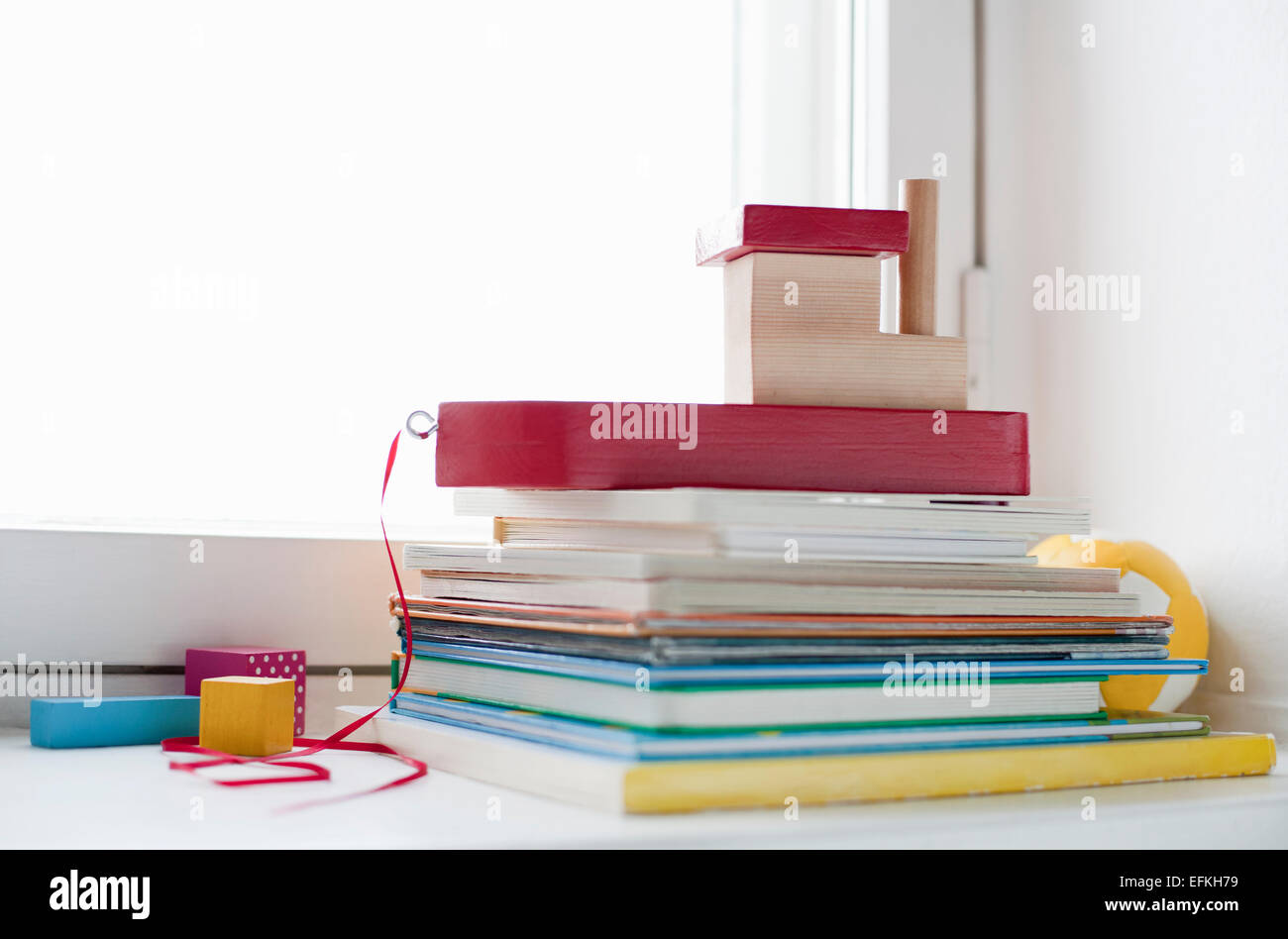 Toy boat on top of books on nursery window ledge Stock Photo - Alamy