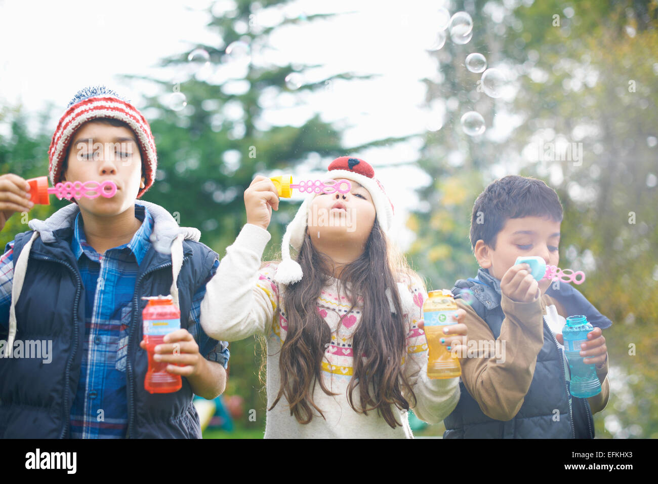 Siblings blowing bubbles in garden Stock Photo - Alamy