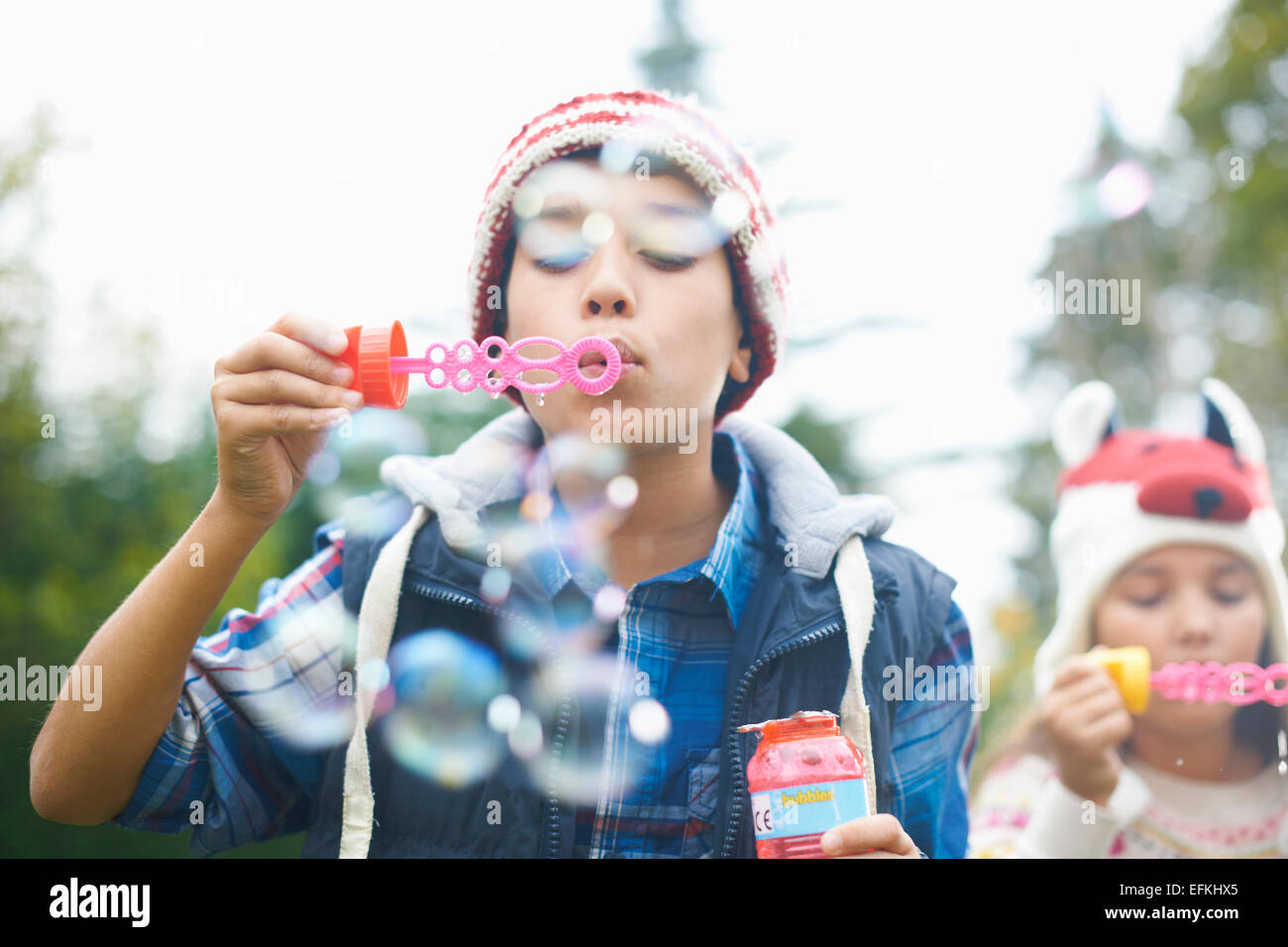 Siblings blowing bubbles in garden Stock Photo - Alamy