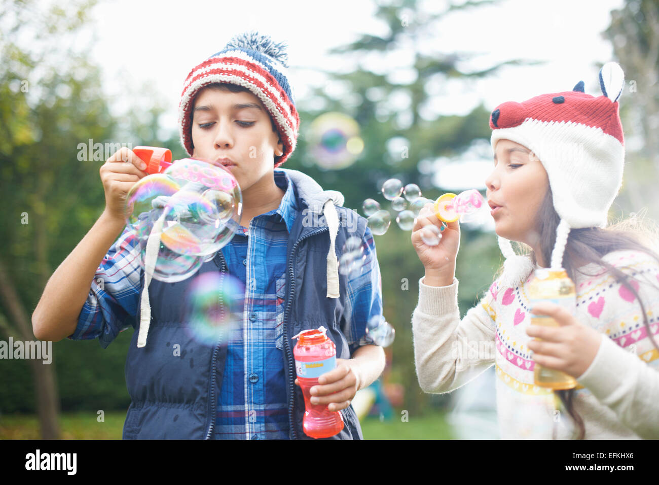 Siblings blowing bubbles in garden Stock Photo - Alamy