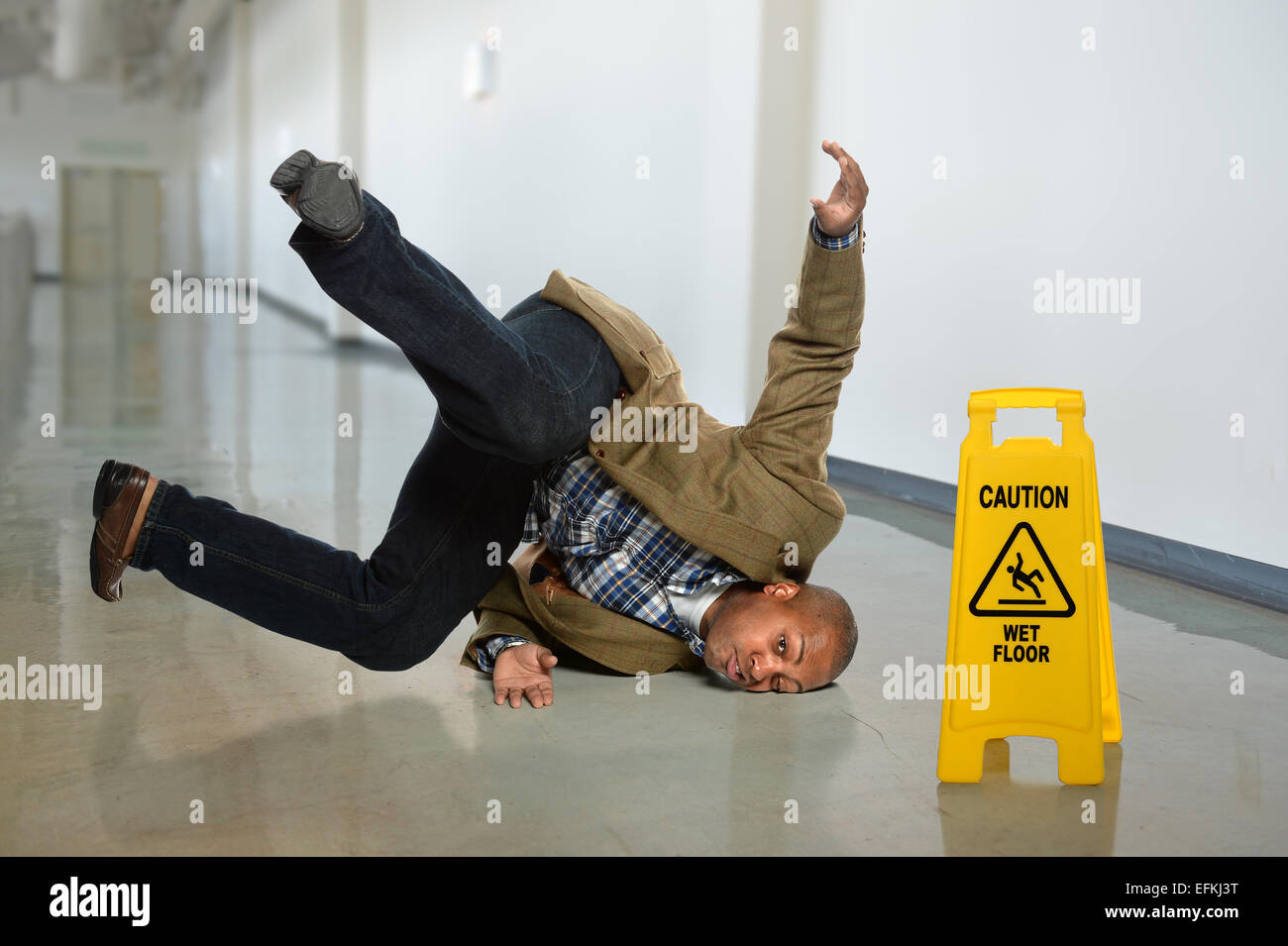 African American businessman falling on wet floor in office Stock Photo ...