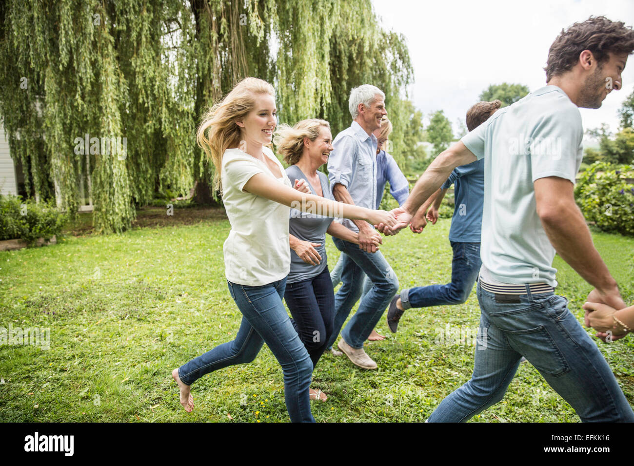 Two generational family running in garden Stock Photo - Alamy