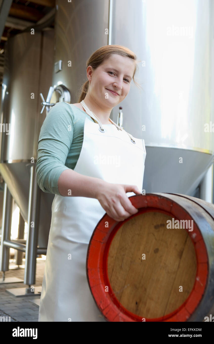 Young woman carrying beer barrel Stock Photo - Alamy