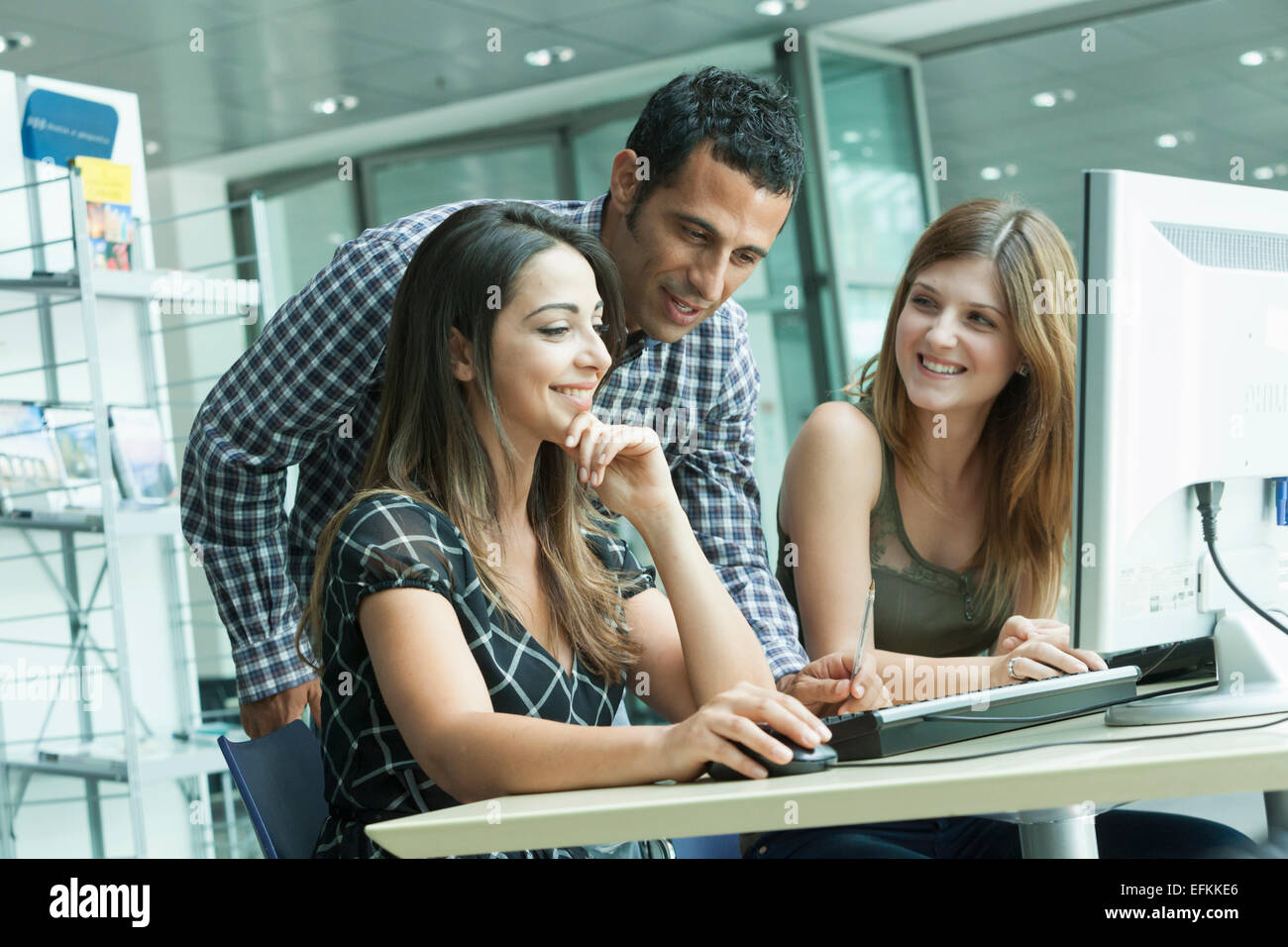 Colleagues having discussion using laptop Stock Photo - Alamy