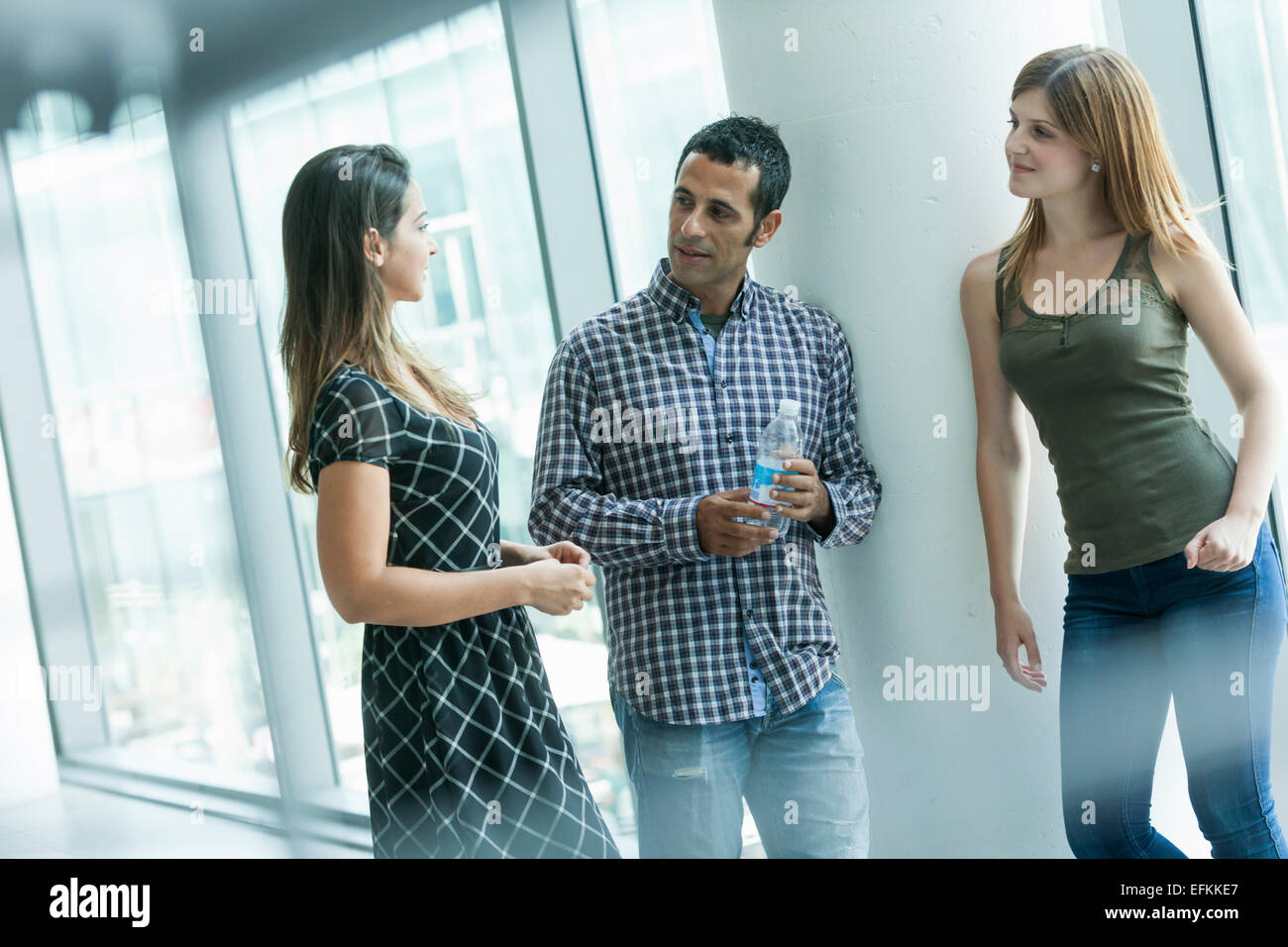 Colleagues having discussion in corridor Stock Photo - Alamy
