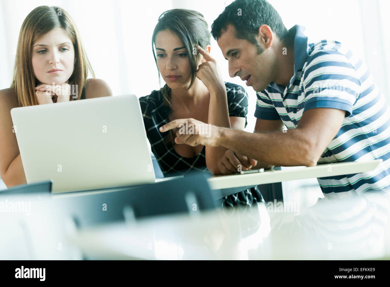 Colleagues having discussion using laptop Stock Photo - Alamy