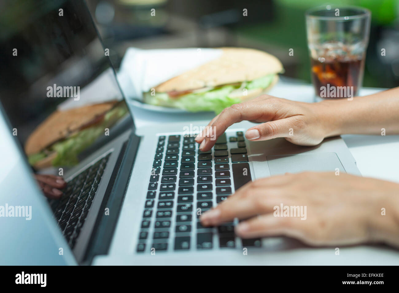 Woman using laptop on working lunch Stock Photo - Alamy