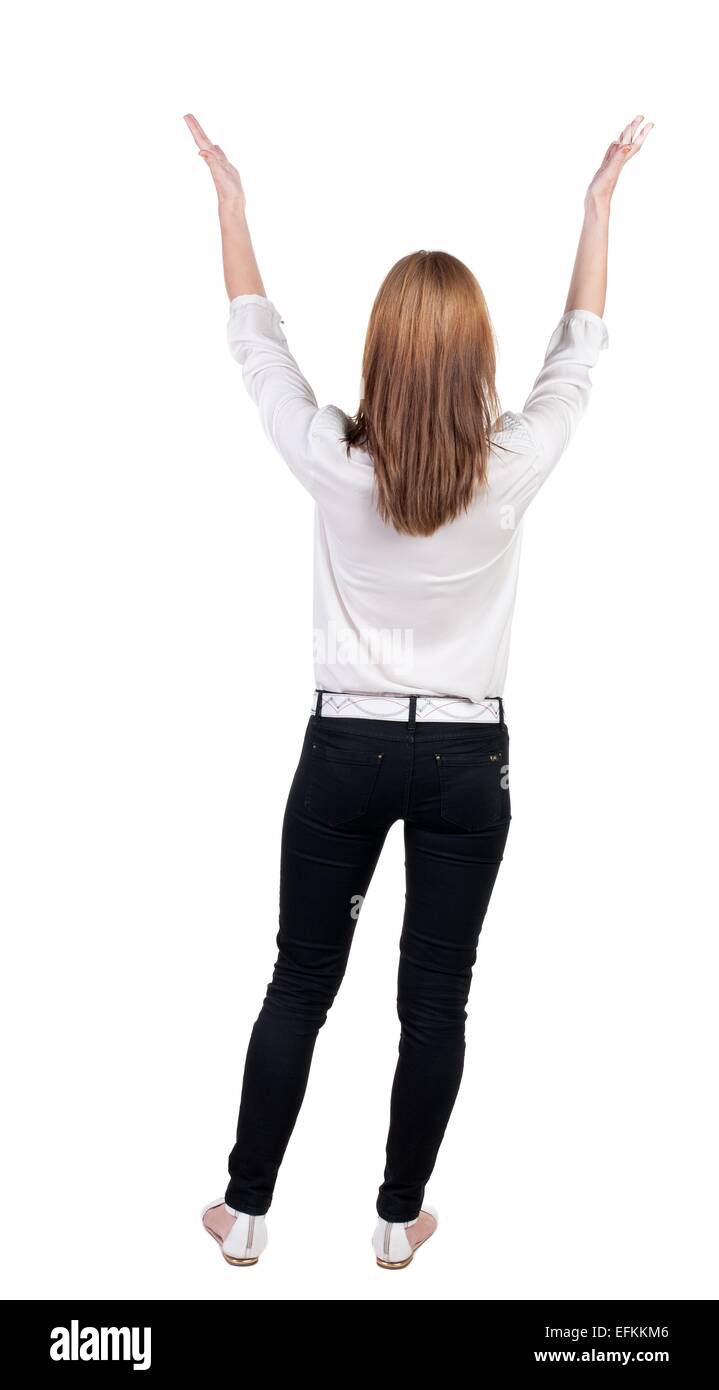 Back view of Beautiful woman in jeans looking at wall and Holds hand up ...