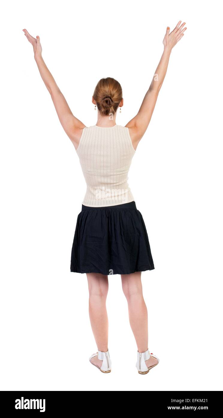Back view of Beautiful woman in dress looking at wall and Holds hand up ...