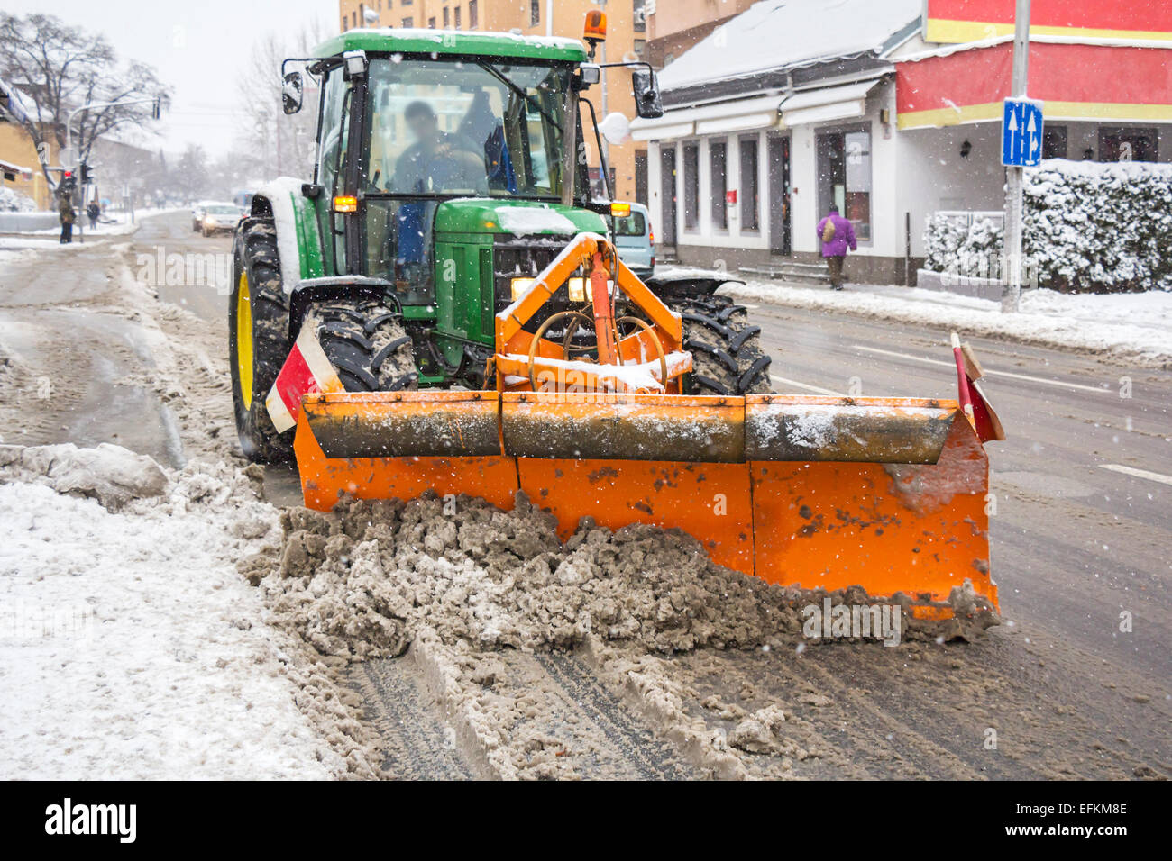 Snowplow tractor removing snow from city road Stock Photo - Alamy